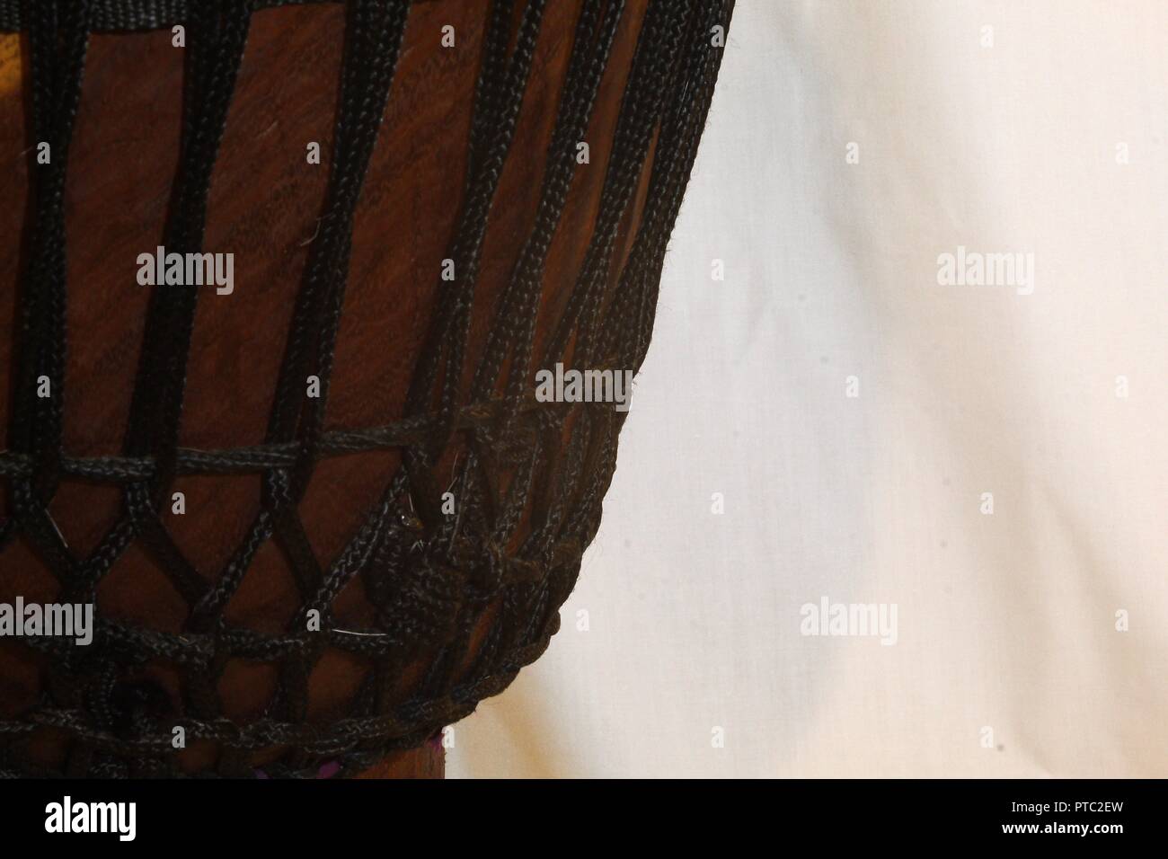 up-close view of a wooden African djembe design with tuning ropes ...