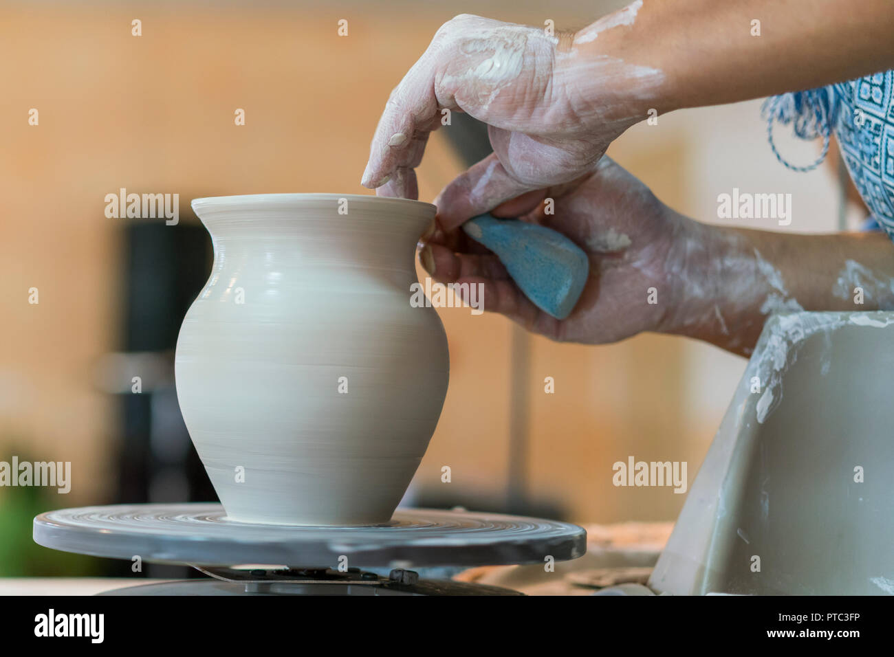 Creating a jar or vase of white clay close-up. Master crock. Man hands ...