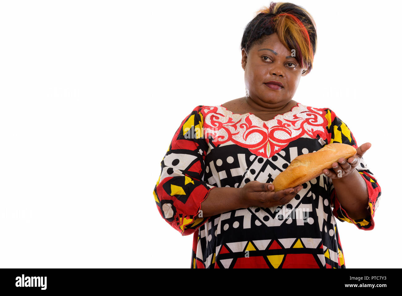 Studio shot of fat black African woman holding bread while think Stock ...