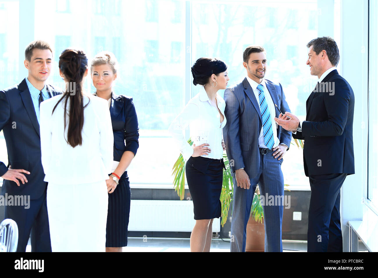 group of business people talking,standing in the lobby of the office ...