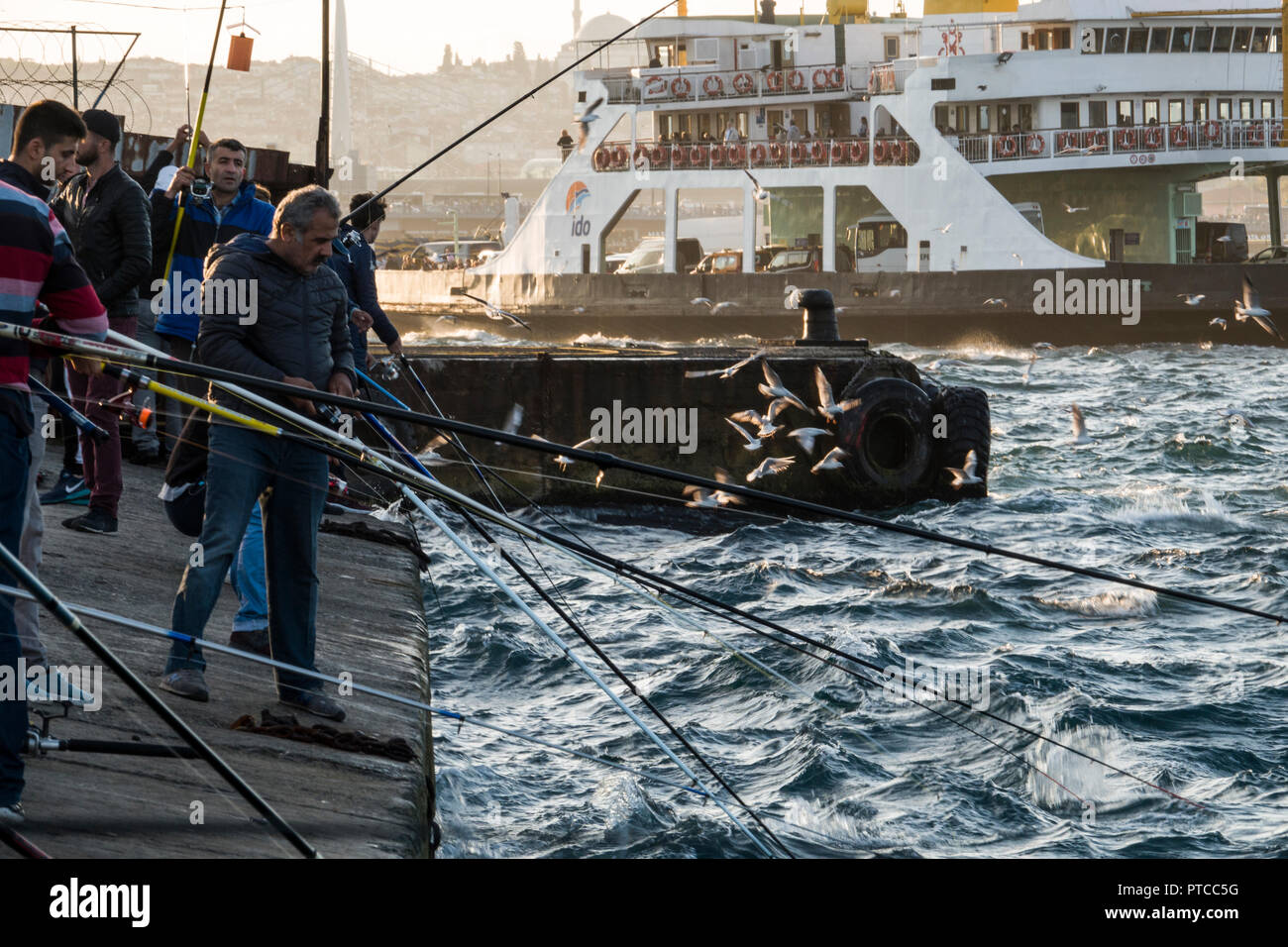 Turkish men recreational fishing along the Bosphorus in Istanbul ...