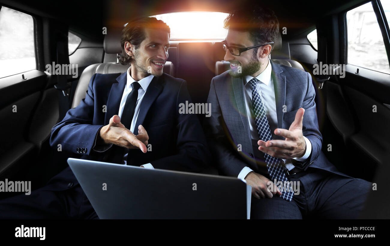 two businessman talking while sitting in the car Stock Photo - Alamy
