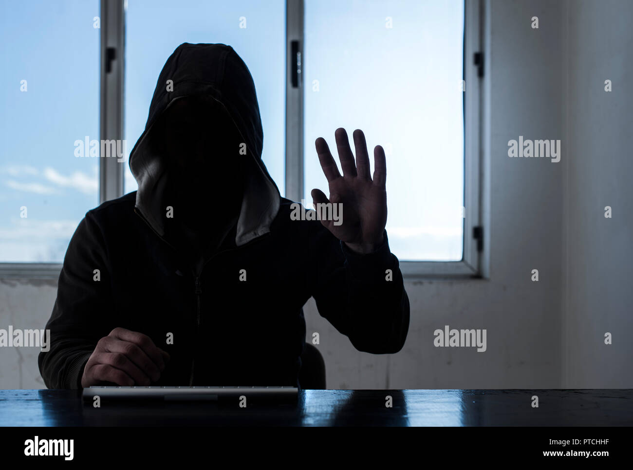 Hacker with laptop. Window in background Stock Photo - Alamy