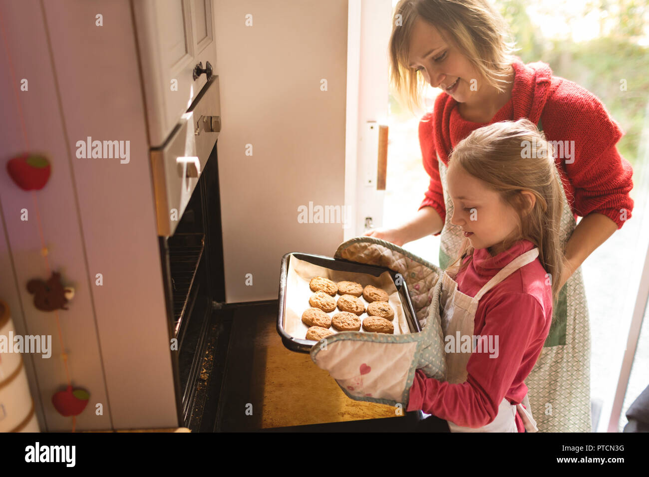 Mother and daughter looking at the baked cookies Stock Photo - Alamy