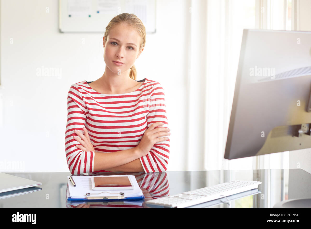 Portrait of casual young woman looking at camera and smiling while ...