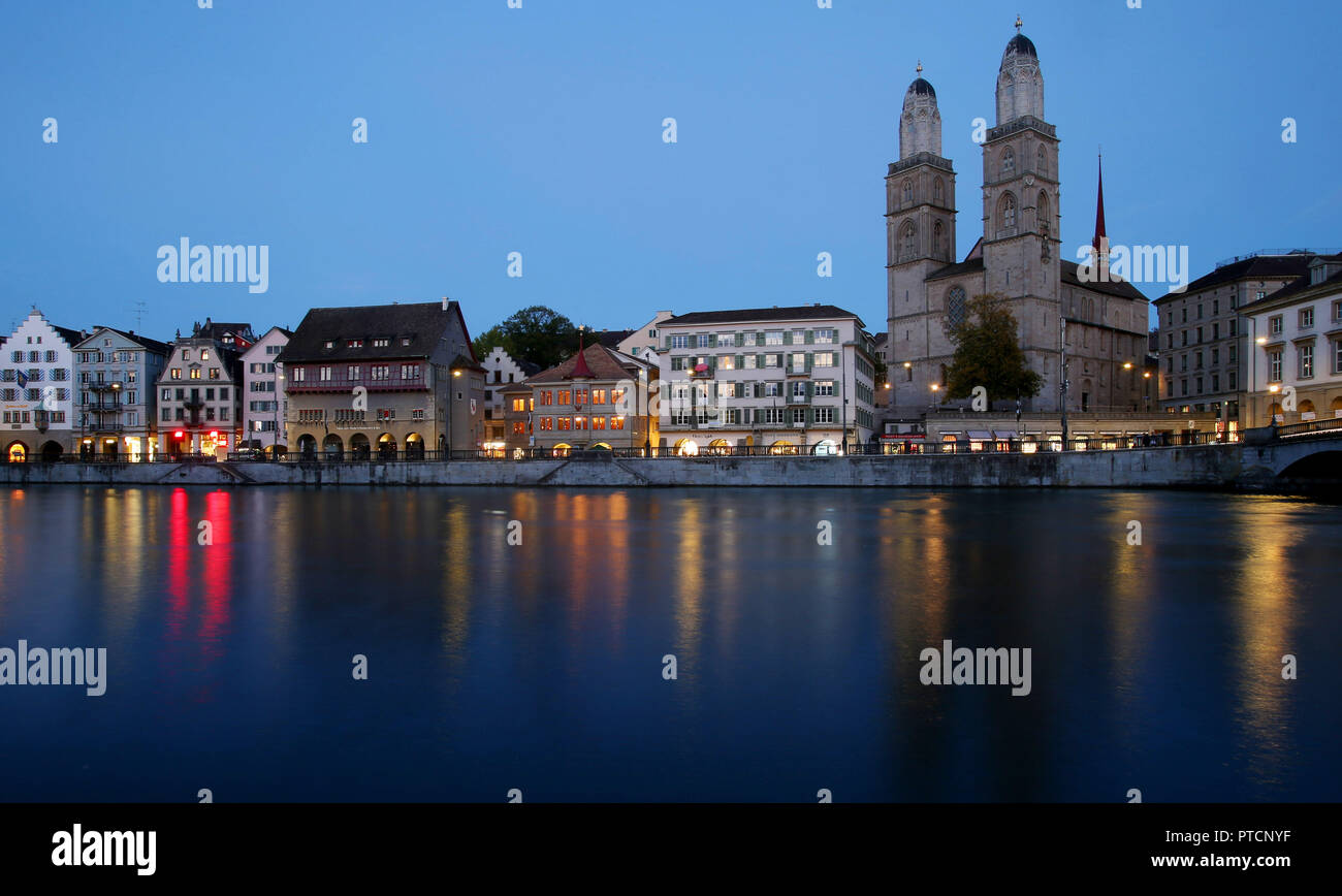 A view of the Grossmunster Tower along the Limmat at dusk in Zurich ...