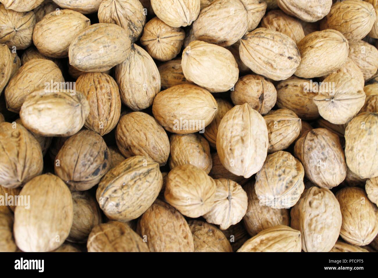 Crude walnut with nutshell for background of texture Stock Photo - Alamy