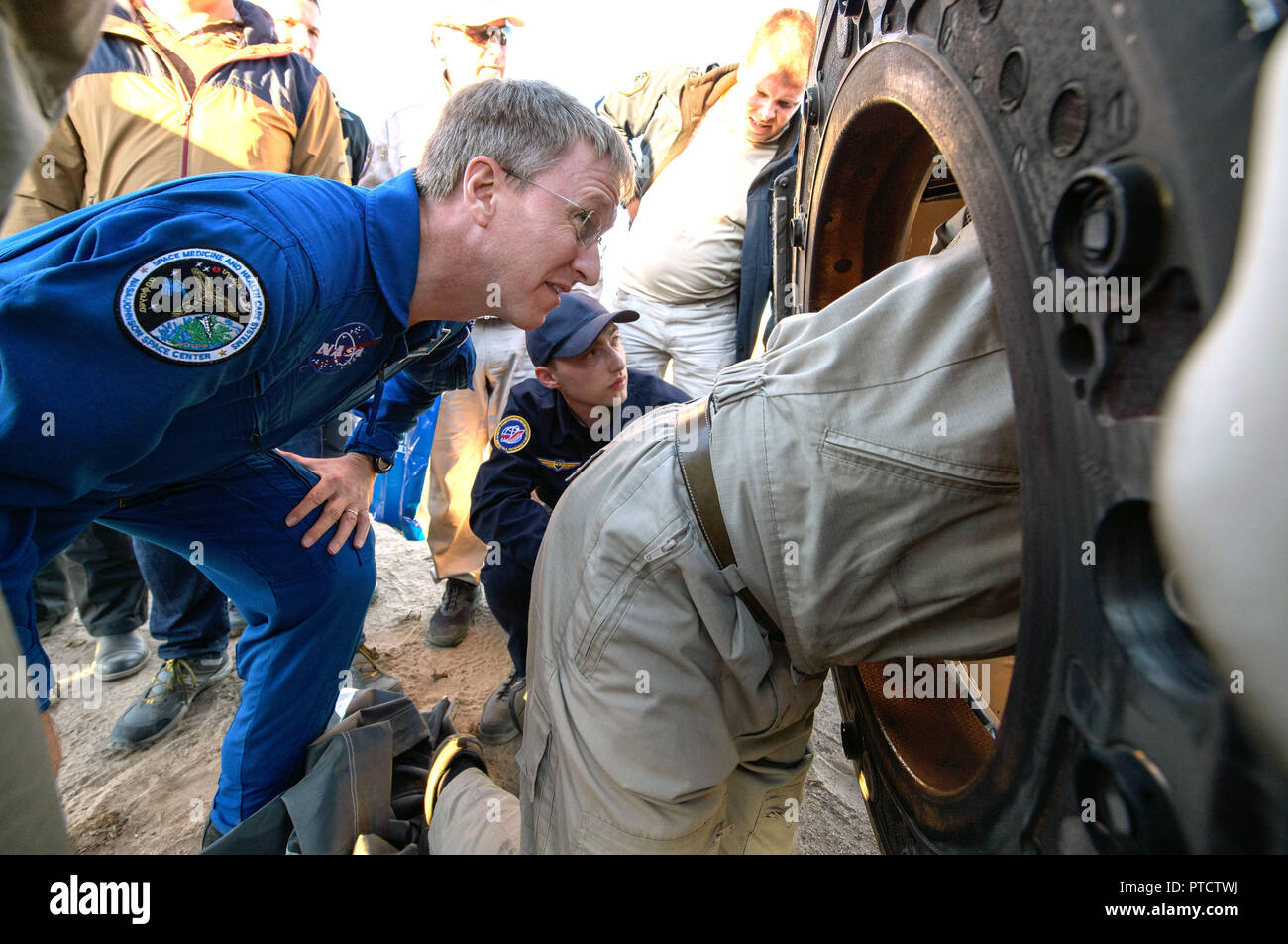 NASA Flight Surgeon Joe Schmid, left, looks into the Russian Soyuz MS ...