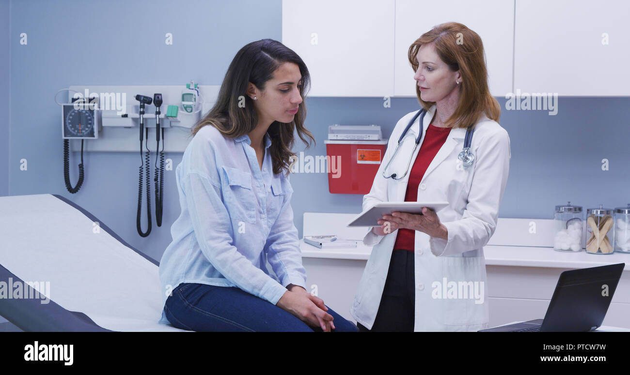 Lovely young latina patient consulting with doctor about health ...