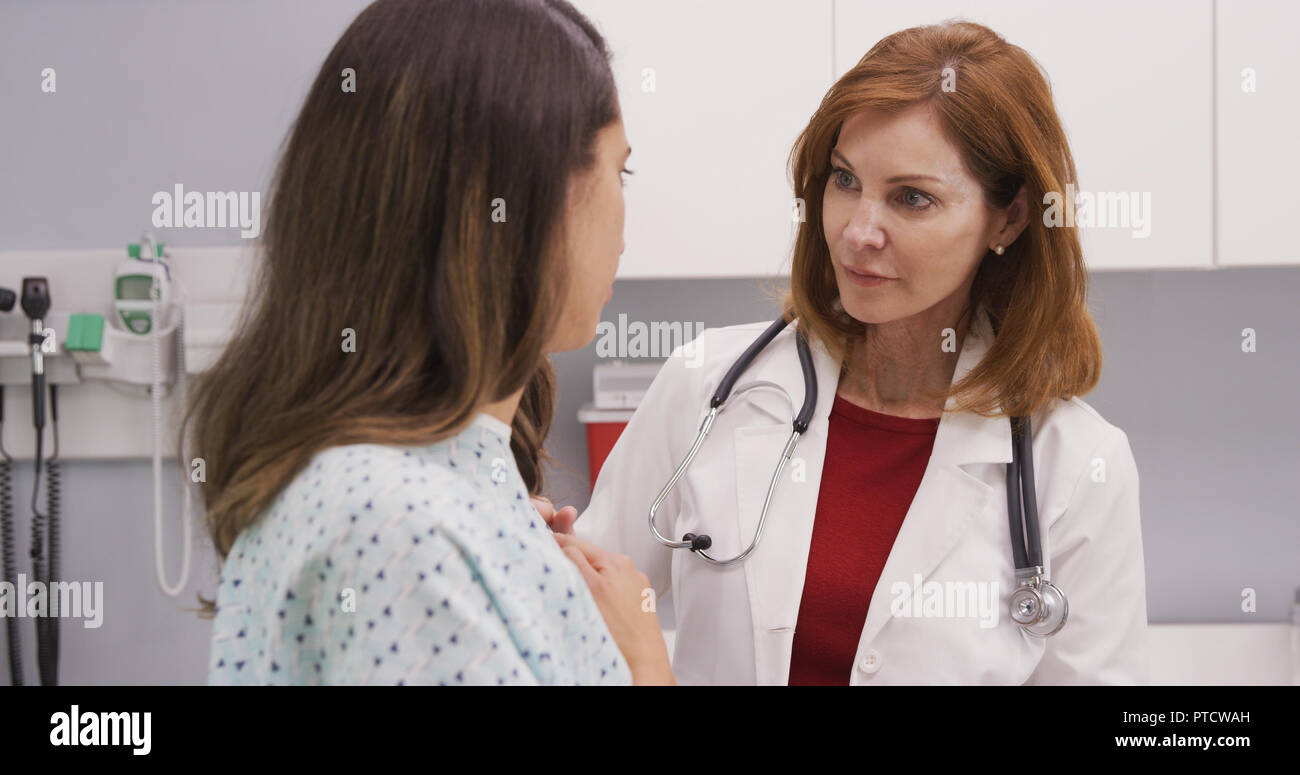 Professional female doctor attending to young latina patient in ...