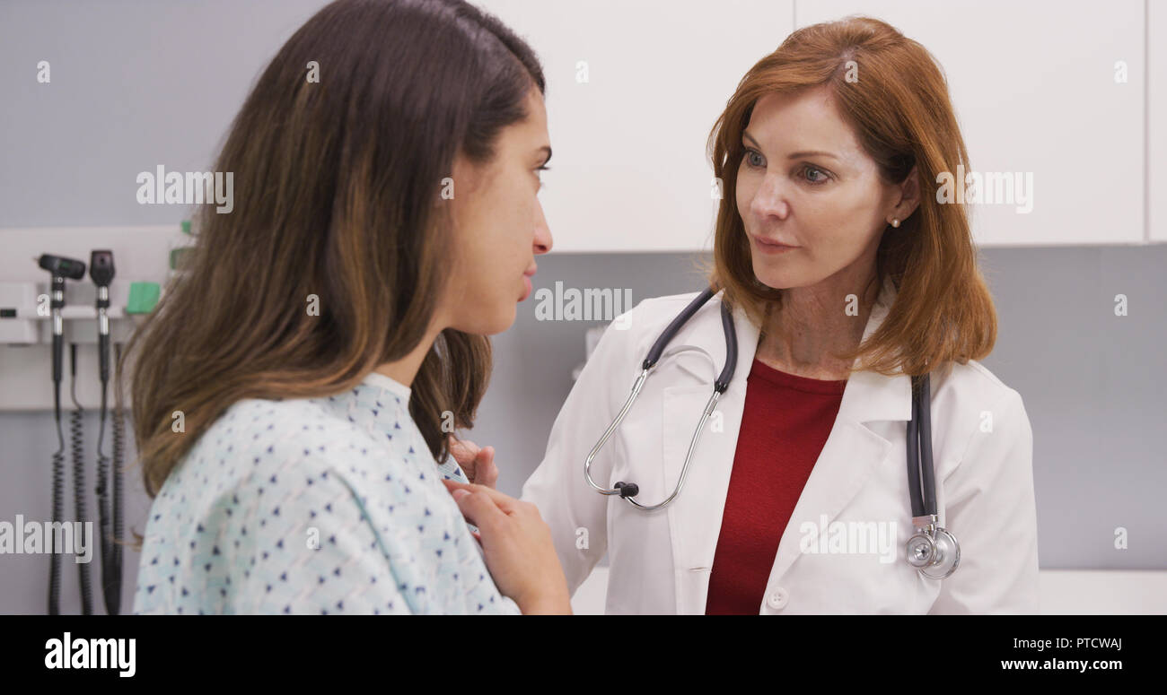 Professional female doctor attending to young latina patient in ...