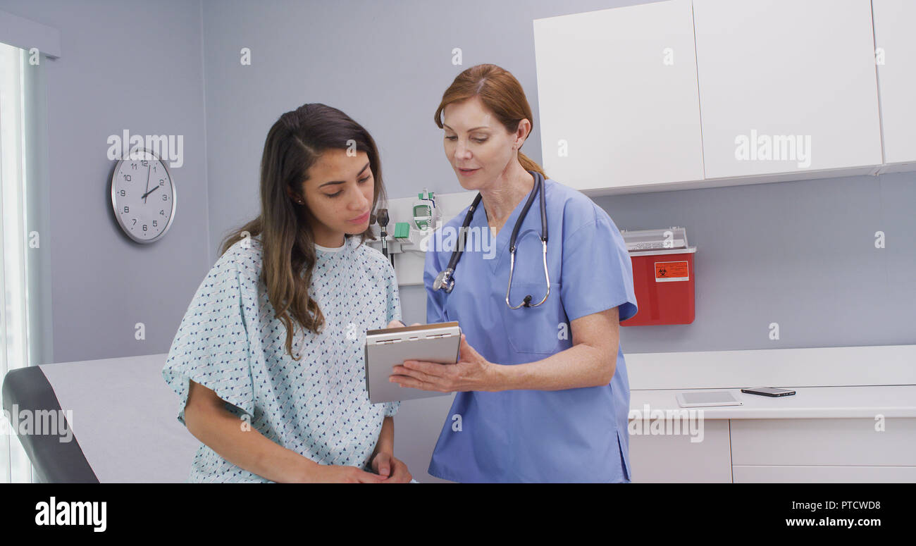 Middle aged medical nurse asking patient questions about general health ...