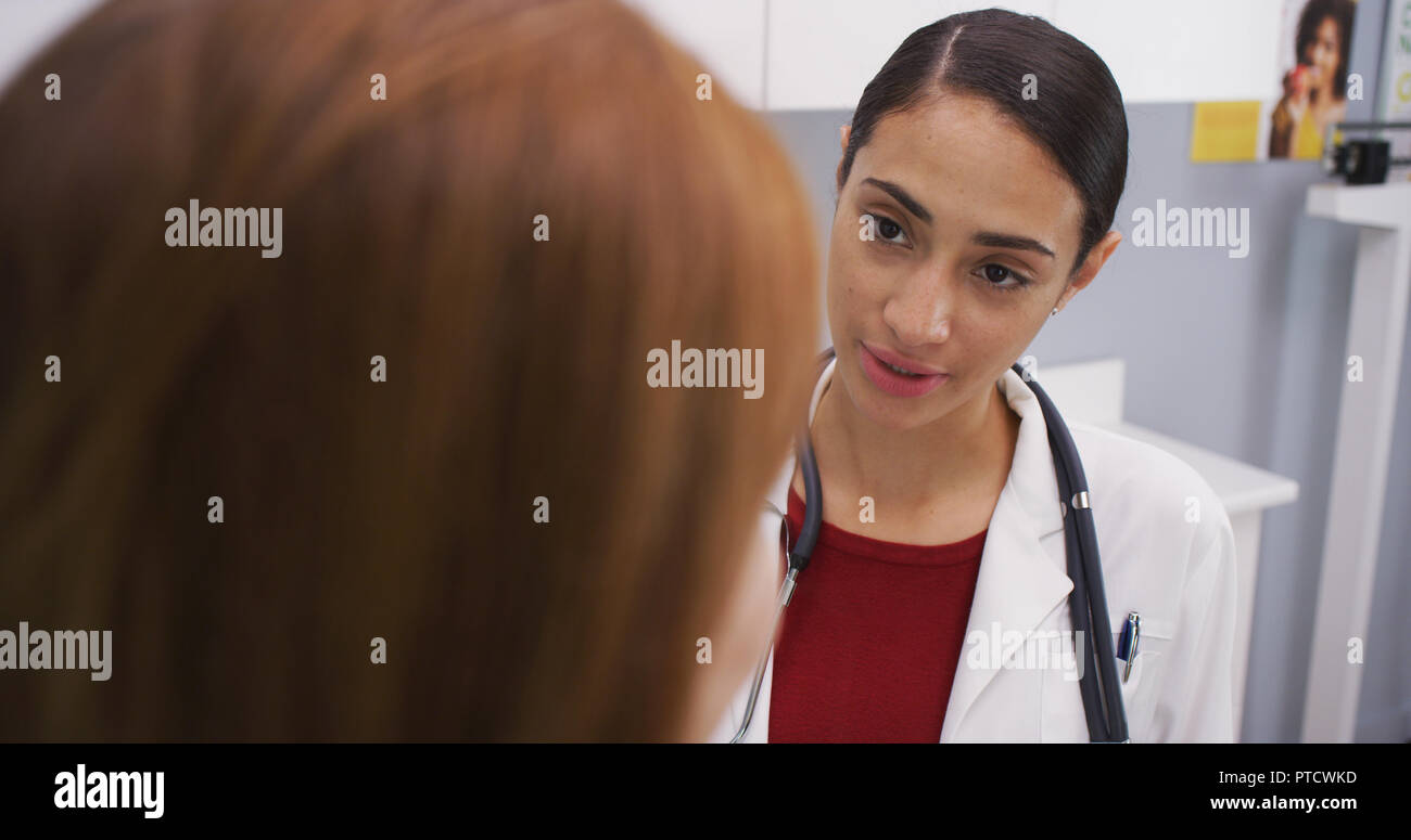 Sympathetic medical doctor attending to senior patient inside hospital ...