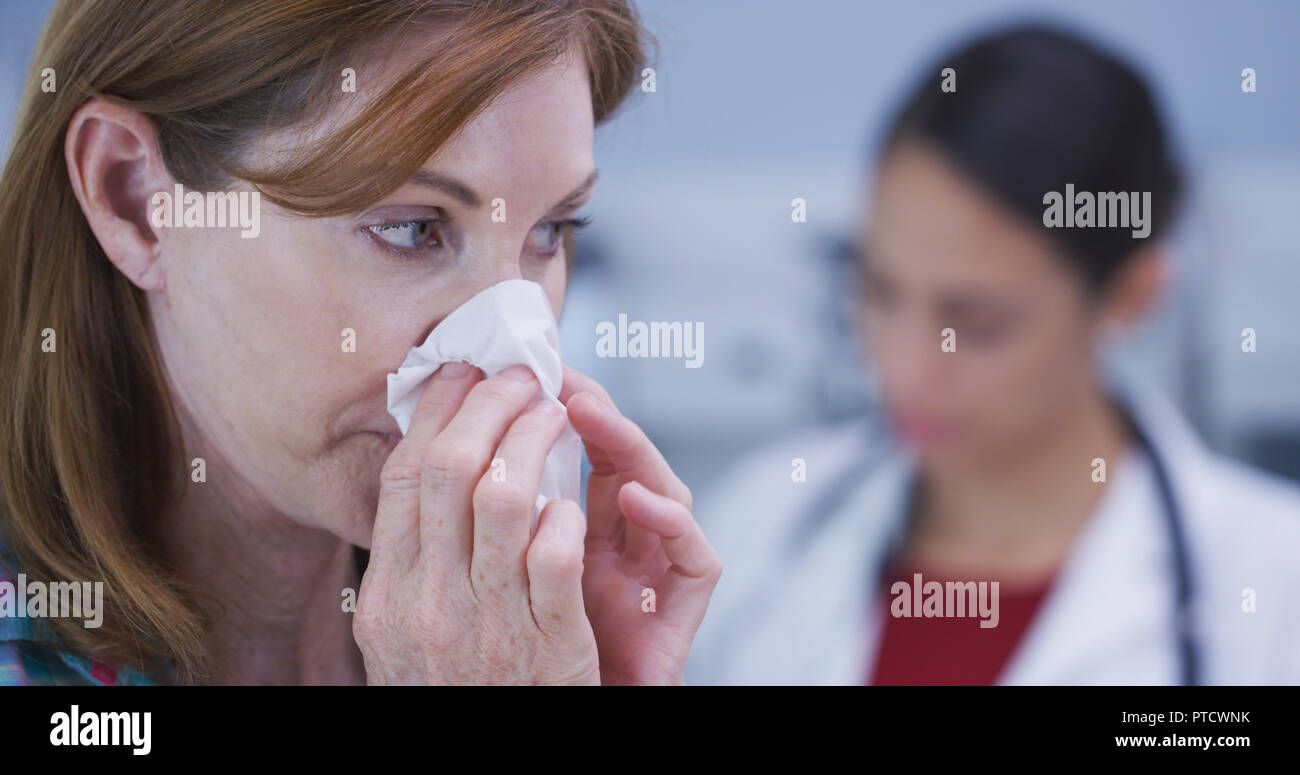 Attractive mid aaged patient blowing nose into tissue paper Stock Photo ...