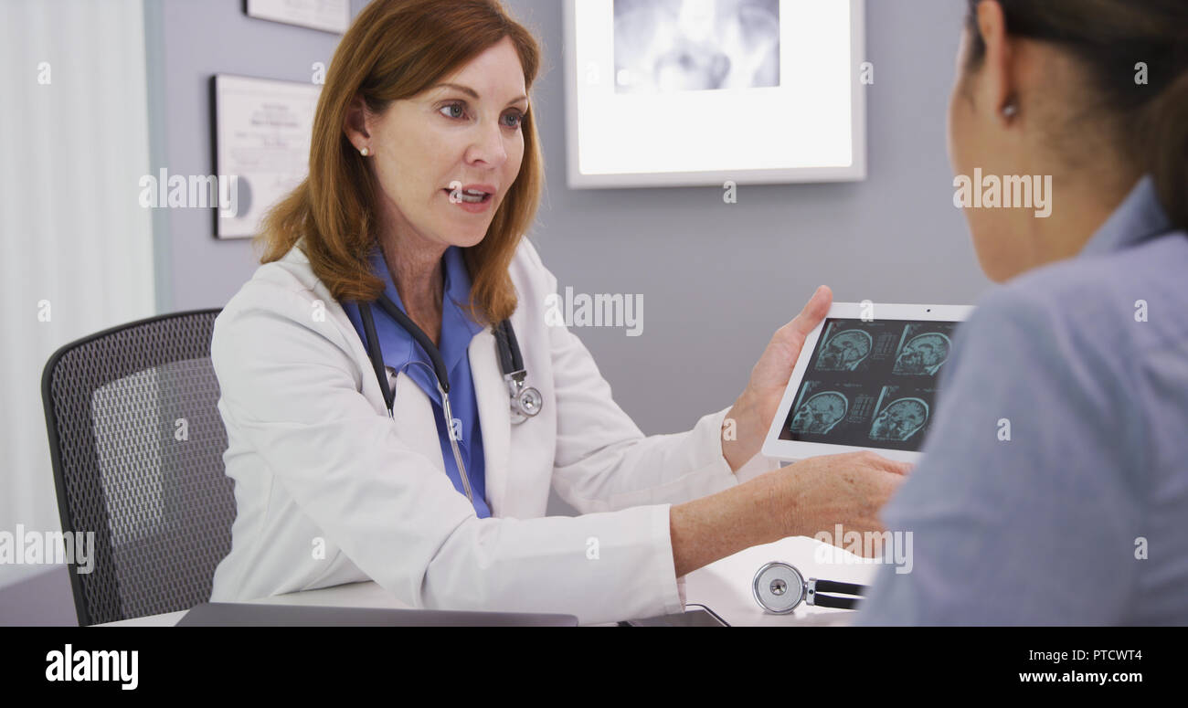 Young patient consulting with doctor over ct-scan indoors medical ...