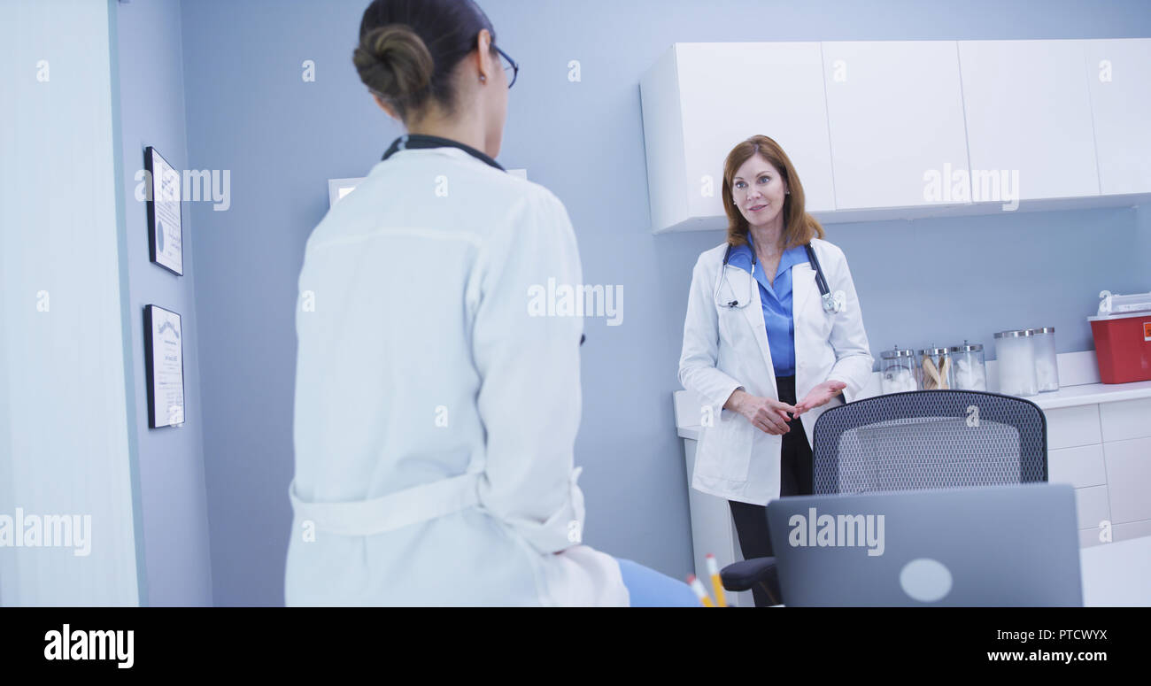 Two medical doctors talking among themselves over patients health ...