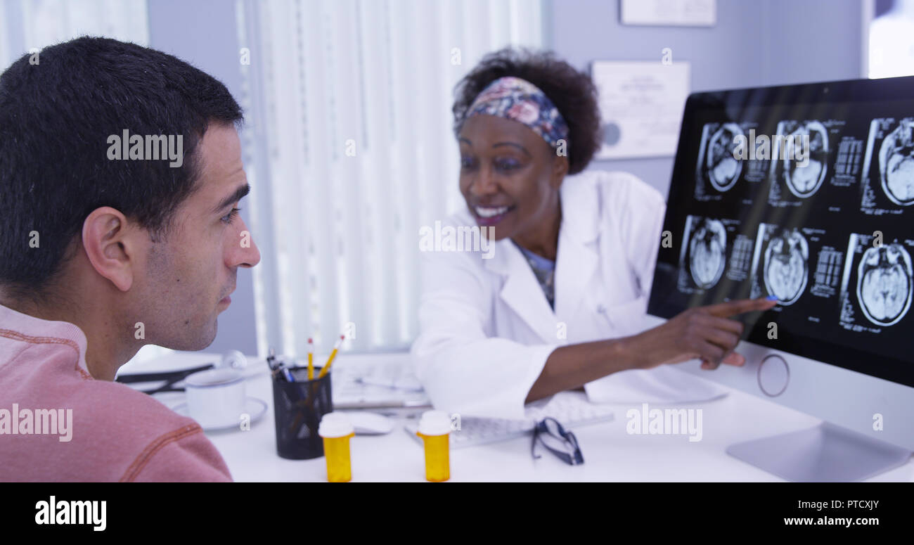 Intelligent female doctor using computer to show scans of patients ...