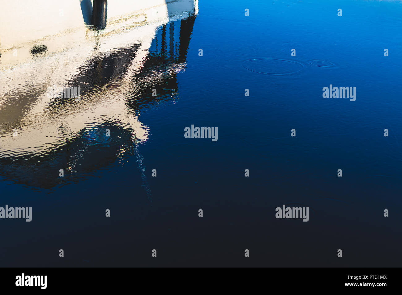 abstract boat reflection on a deep blue dark harbor with ripples Stock ...