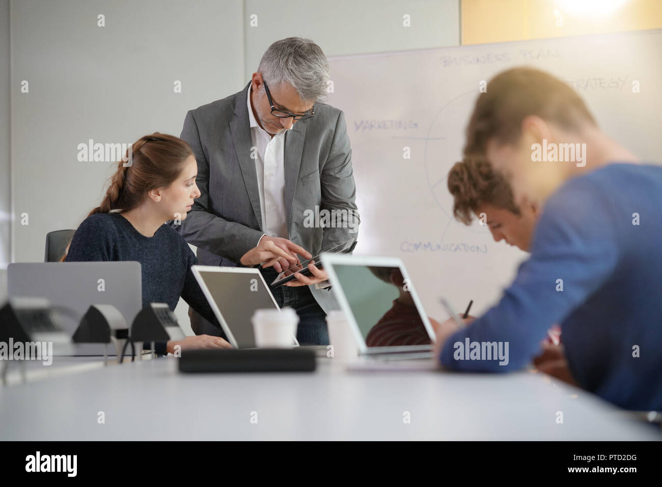 Teacher giving economics class, using whiteboard Stock Photo - Alamy