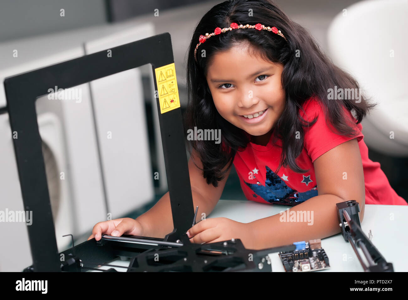 Little girl learning and working hands on, building a 3D printer with ...