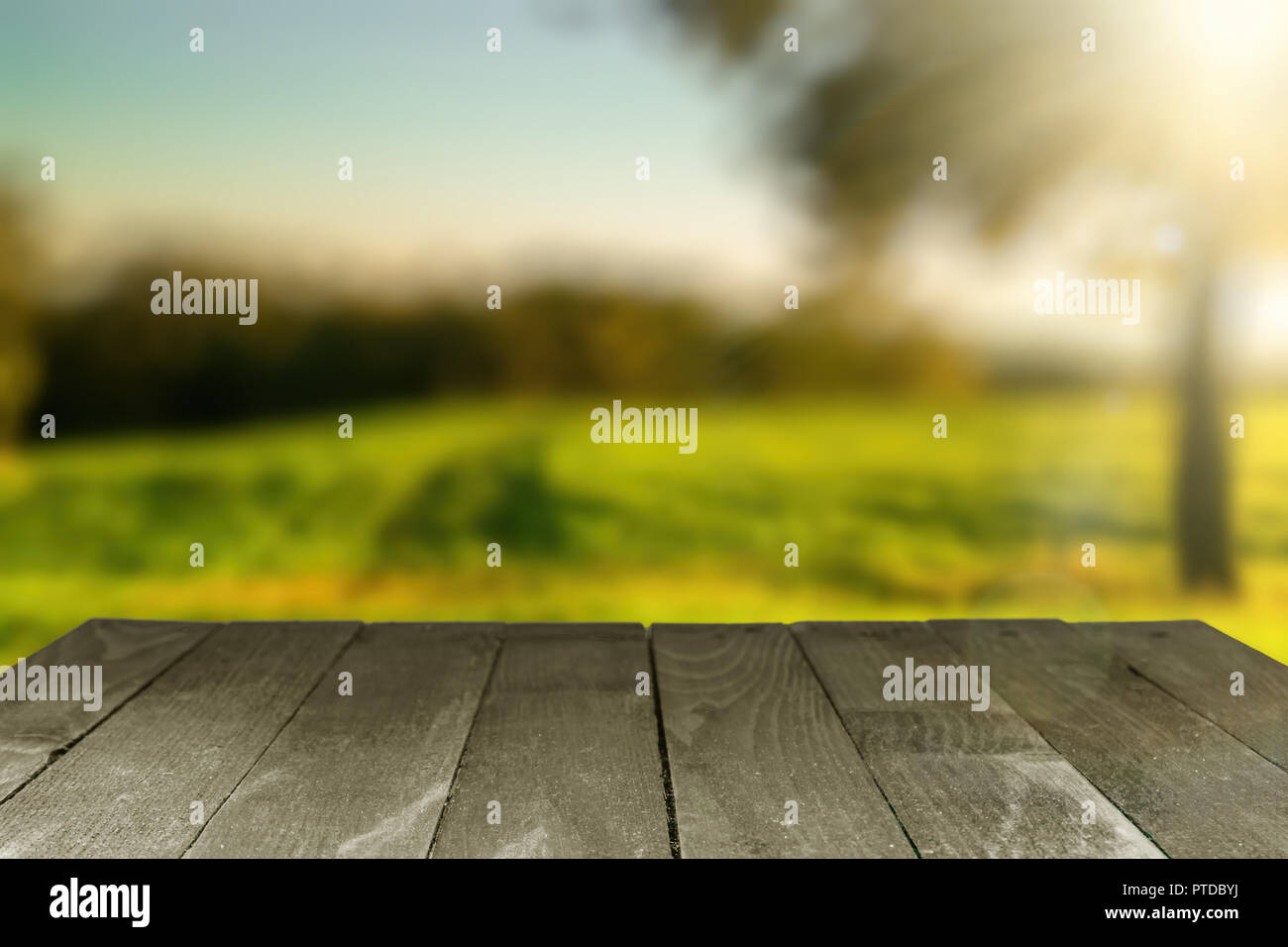 Wooden table backdrop against rural scene, mock up advertisement Stock ...