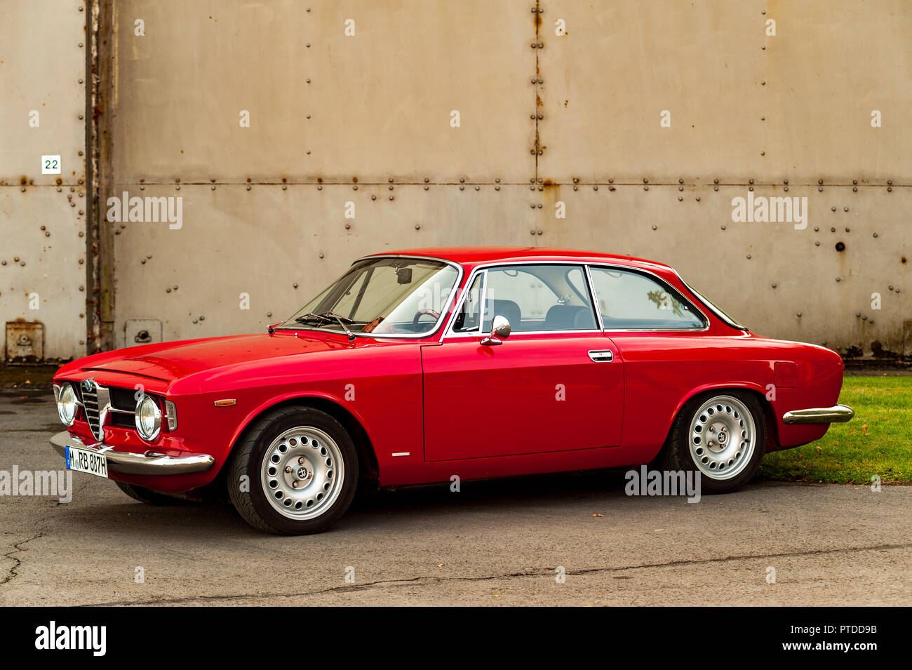 Classic Italian saloon in red Alfa Romeo Guilia 1600 against hanger ...