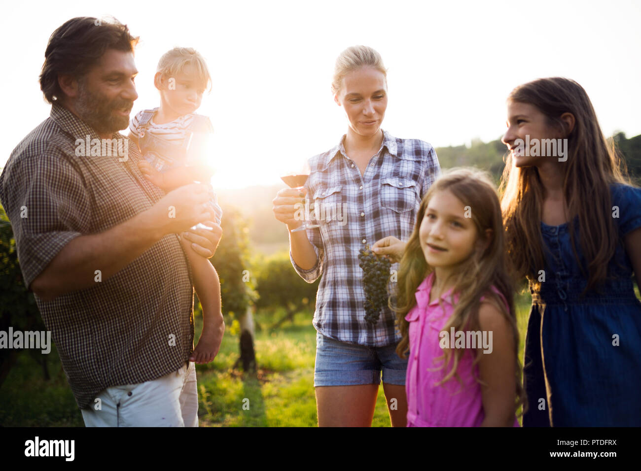 Wine grower family in vineyard tasting nice vine Stock Photo - Alamy