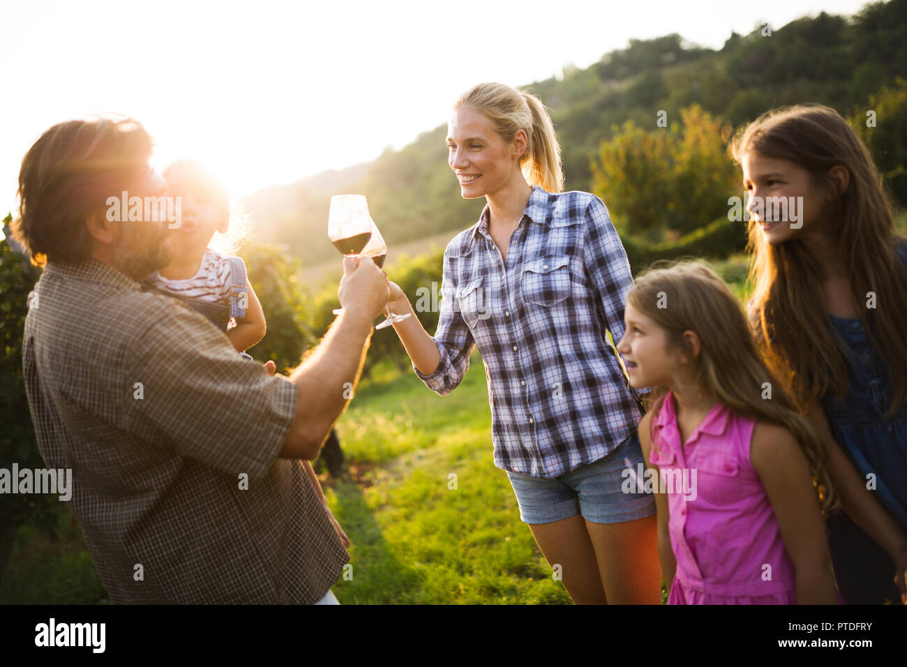 Wine grower family in vineyard tasting nice vine Stock Photo - Alamy