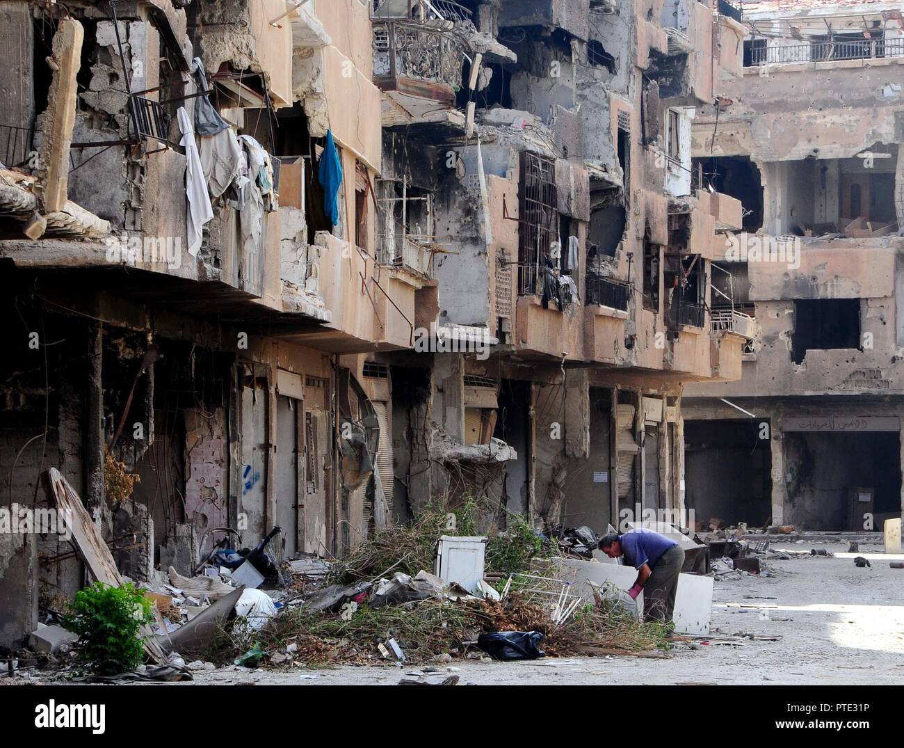 Damascus, Syria. 9th Oct, 2018. A Syrian man looks for his belongings ...