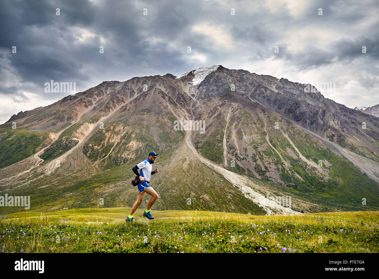 Runner athlete with beard running on the trail in the mountains Stock ...