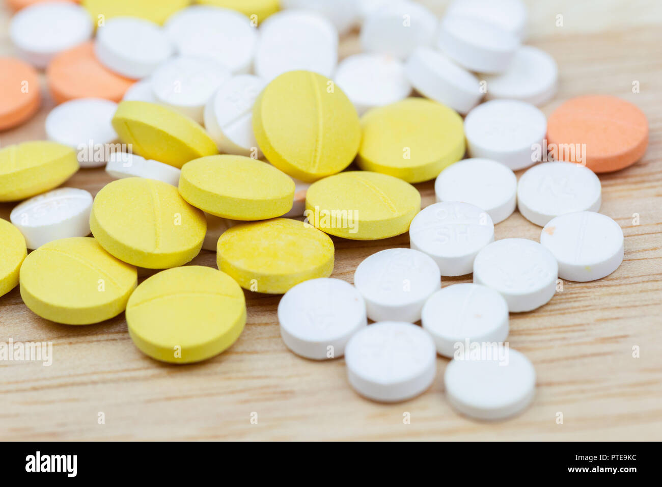 Colorful medicine pills tablets or drugs closeup on wood table ...