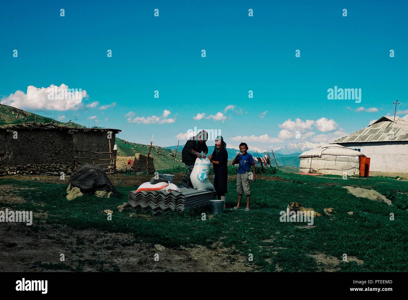 Osh / Kyrgyzstan - MAY 21 2011: family preparing grain for the chicken ...