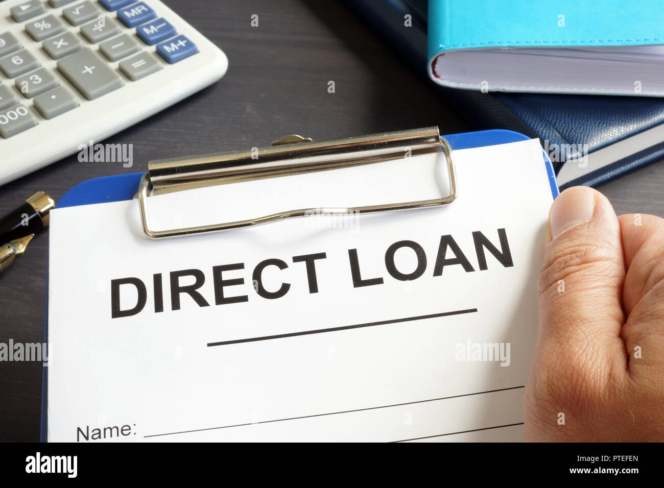 Man is holding Direct loan form and clipboard Stock Photo - Alamy