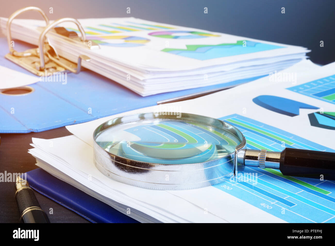 Financial audit report and magnifying glass on a desk Stock Photo - Alamy