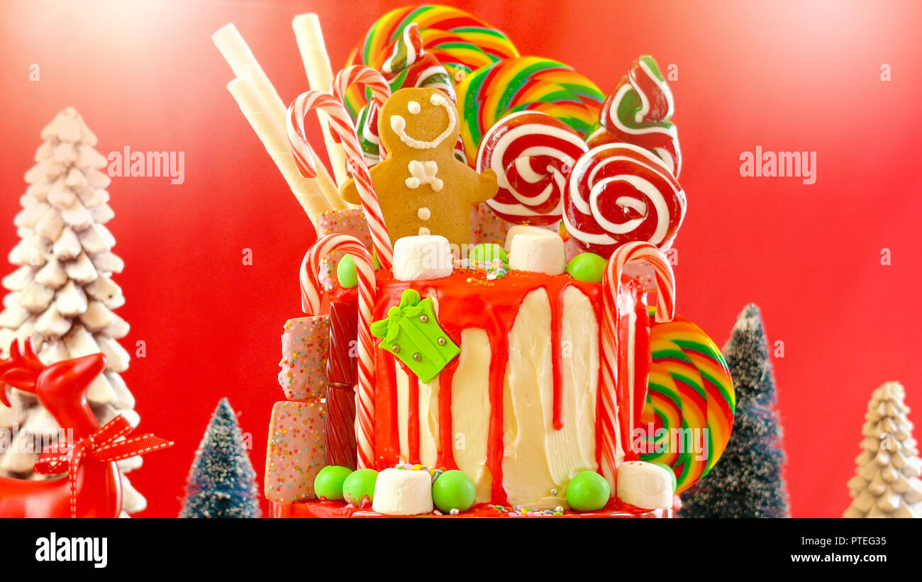 On trend festive candyland Christmas drip cake on red background Stock ...