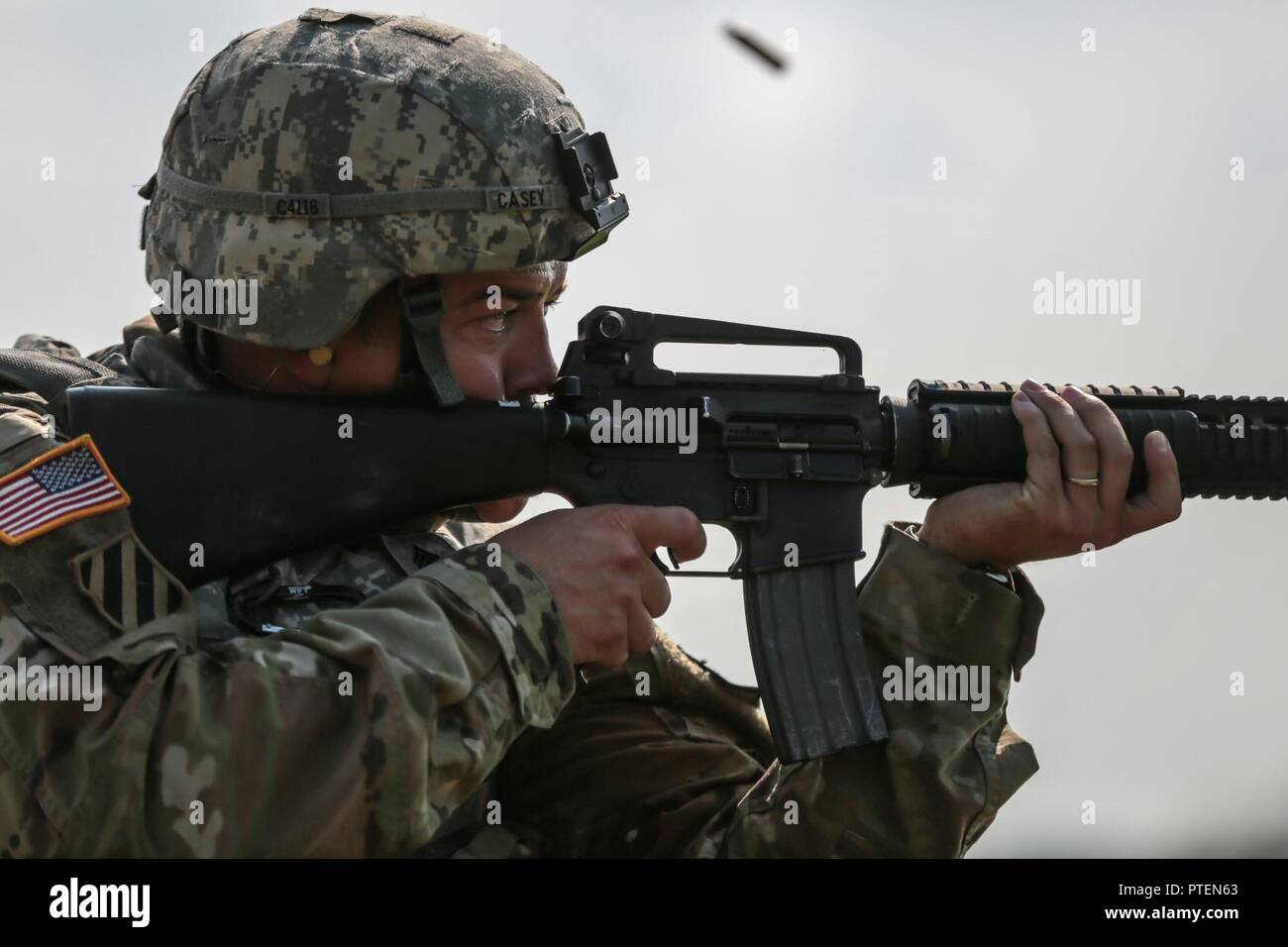 U.S. Army Staff Sgt. Jared Casey fires a M16 rifle in the kneeling ...