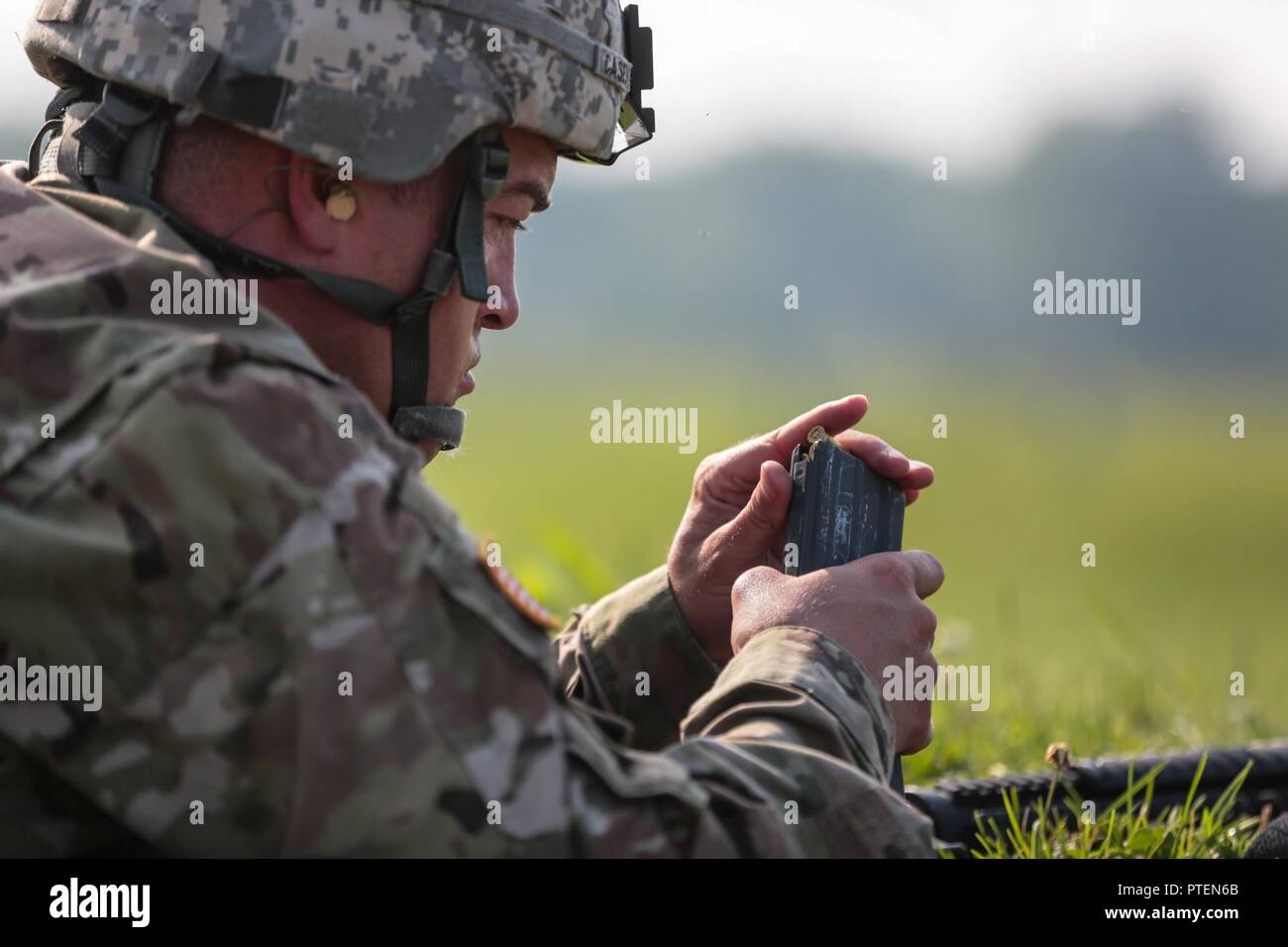 U.S. Army Staff Sgt. Jared Casey loads a 5.56mm bullet into a magazine ...