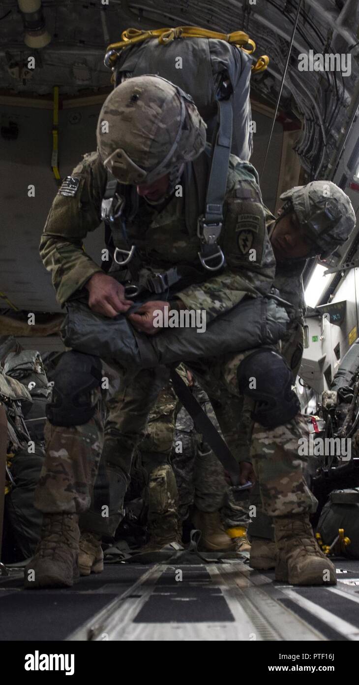 U.S. Army Spc. Isaiah Madalora assists U.S. Army Sgt. Zachary Hudson ...