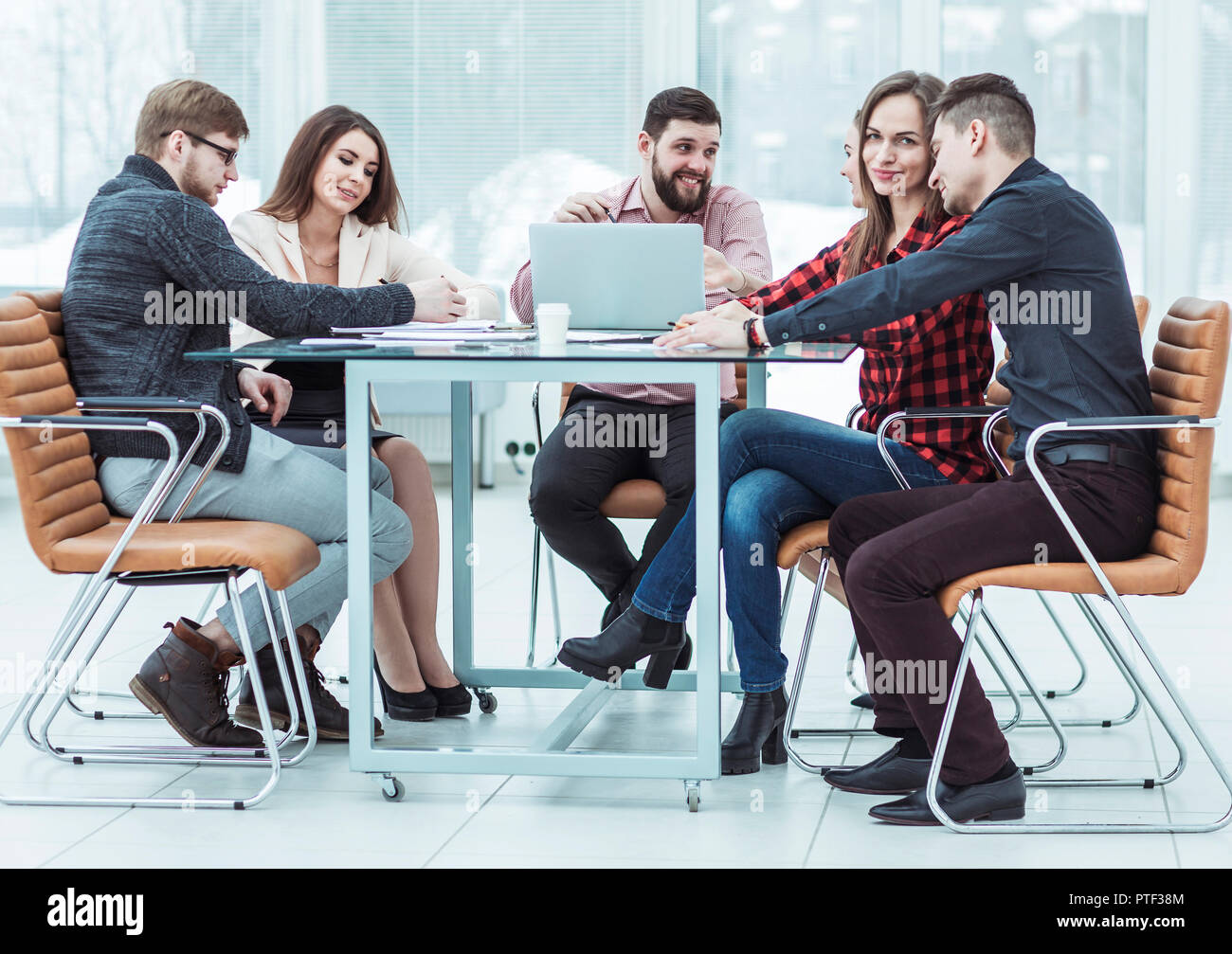 business team discussing work documents sitting behind a Desk Stock ...
