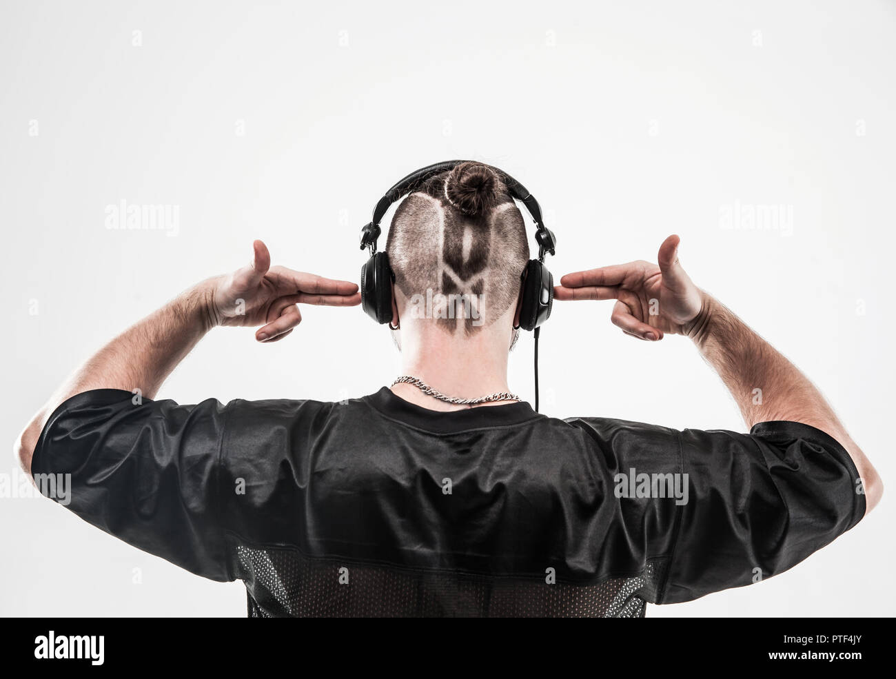 rear view - DJ - rapper with a stylish hairstyle with headphones Stock ...