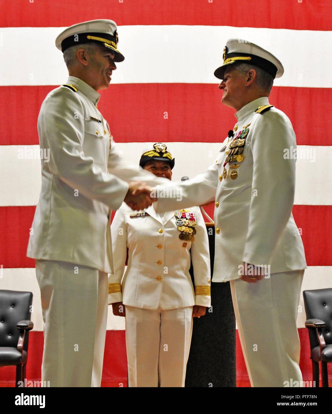 Capt. Philip Brock and Capt. Steve Banta shake hands as Rear Adm. Bette ...