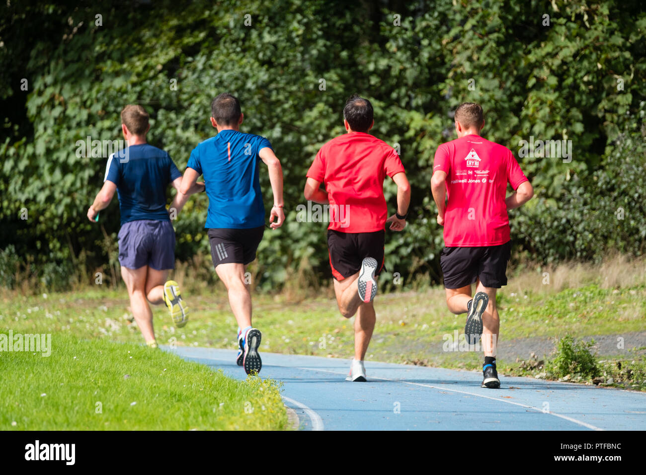 Health and fitness: Rear view of four men running on a track, UK Stock ...
