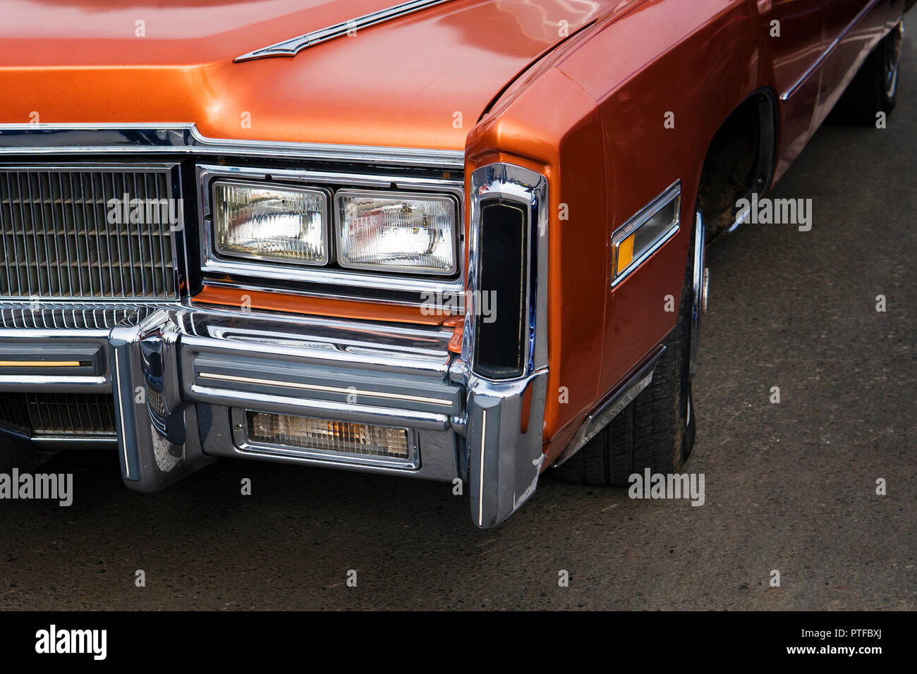 A closeup of the headlights and front bumper on a vintage American ...
