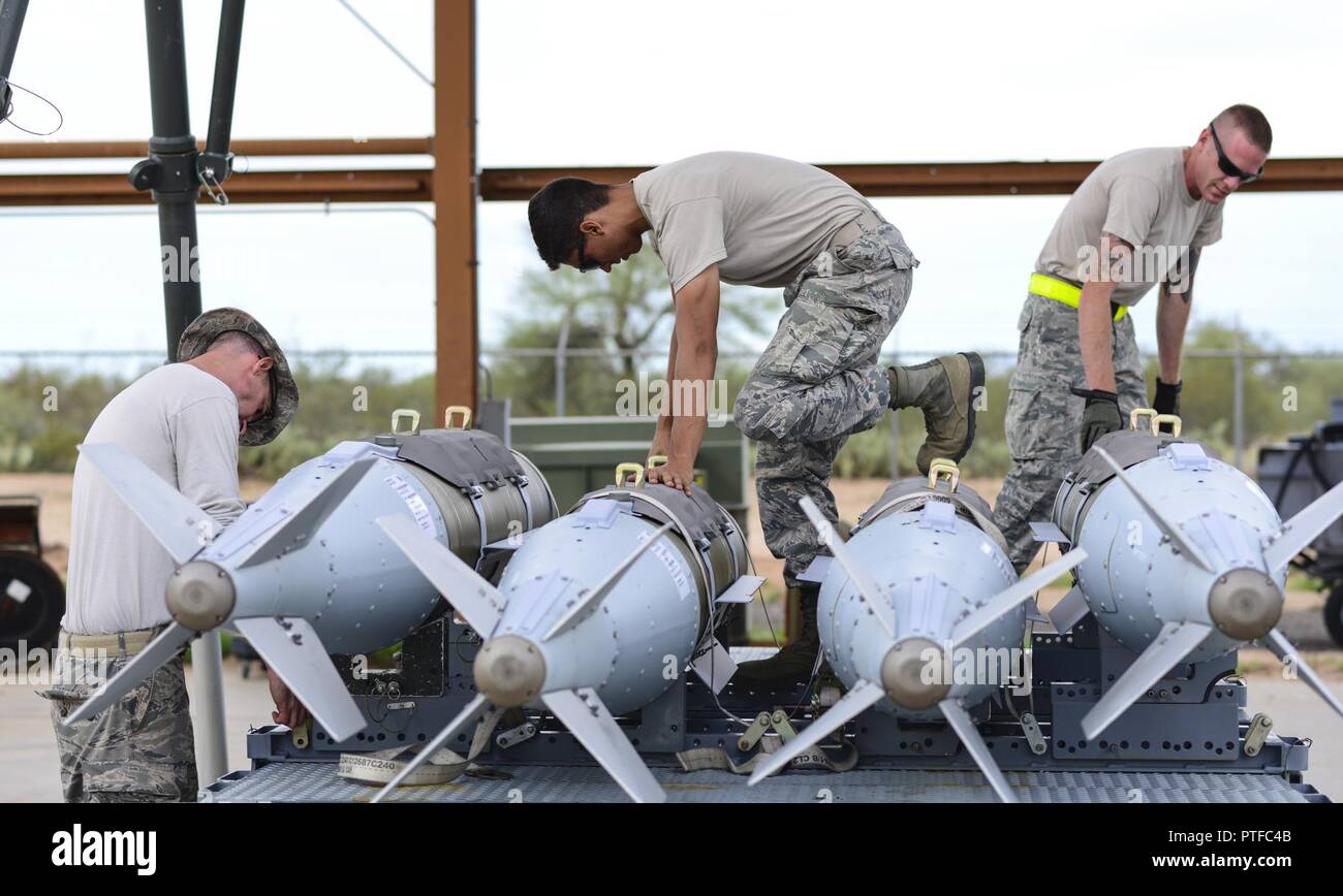 U.S. Airmen unload GBU-31 joint direct attack munitions from a trailer ...