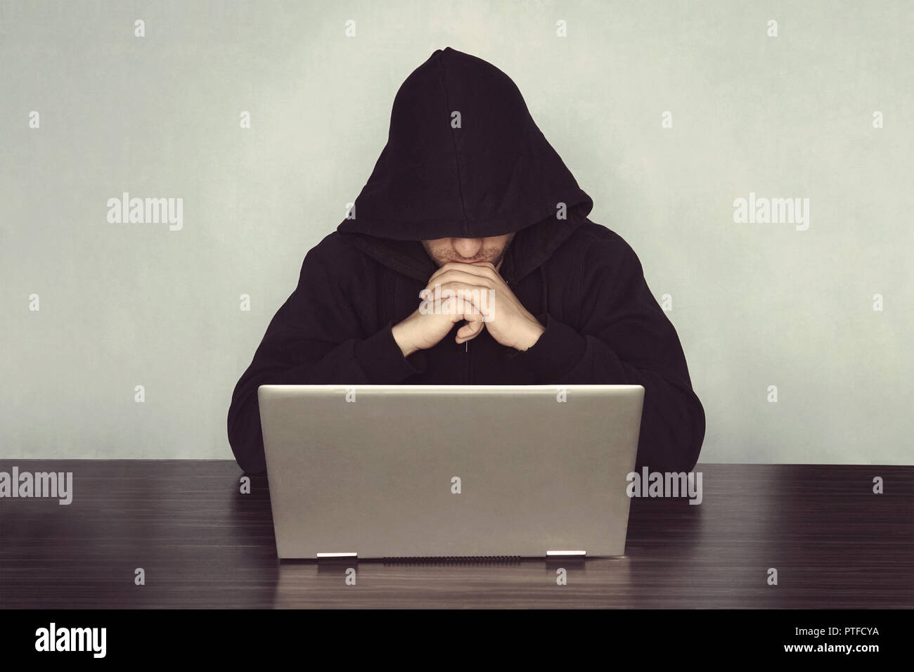 Hacker with his computer thinking on light blue background. monk hermit ...
