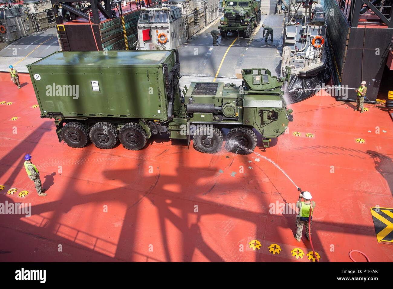 U.S. Marines with 1st Marine Logistics Group wash an AMKR18 Logistics ...