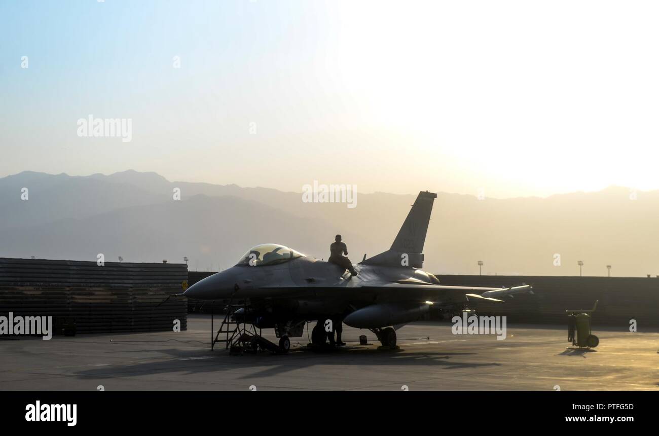 A maintenance Airman inspects an F-16 Fighting Falcon in the setting ...