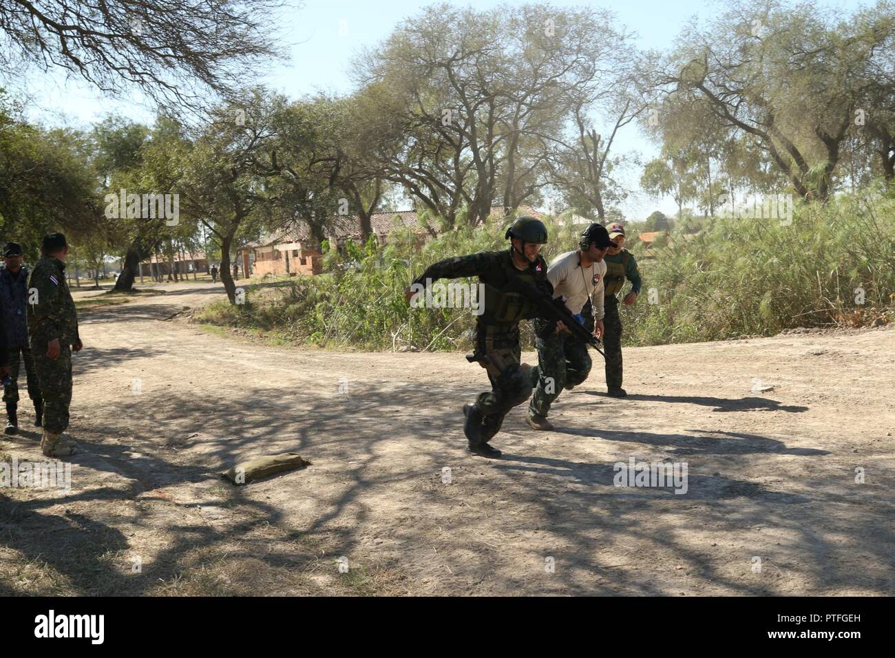 A Peruvian Fuerzas Comando competitor sprints with a judge to begin a ...