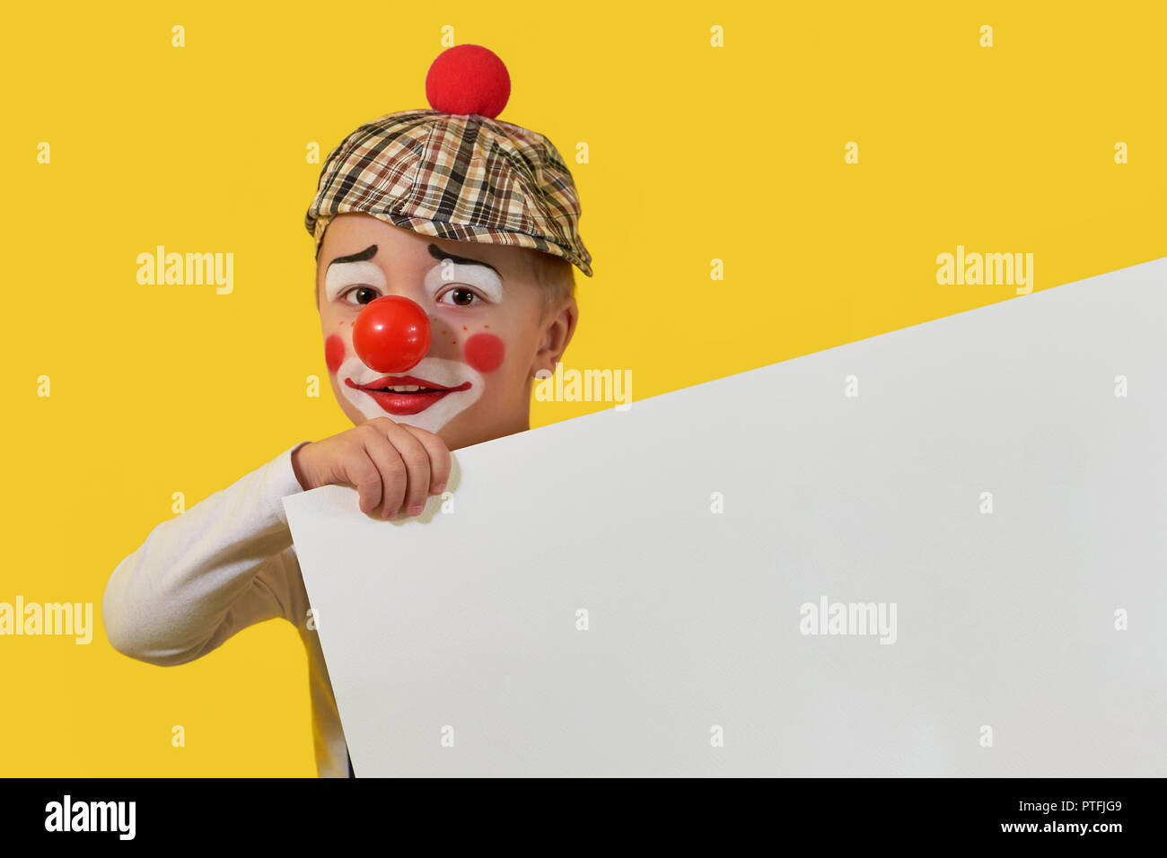 Funny child clown with blank white paper. Cute little boy clown in ...