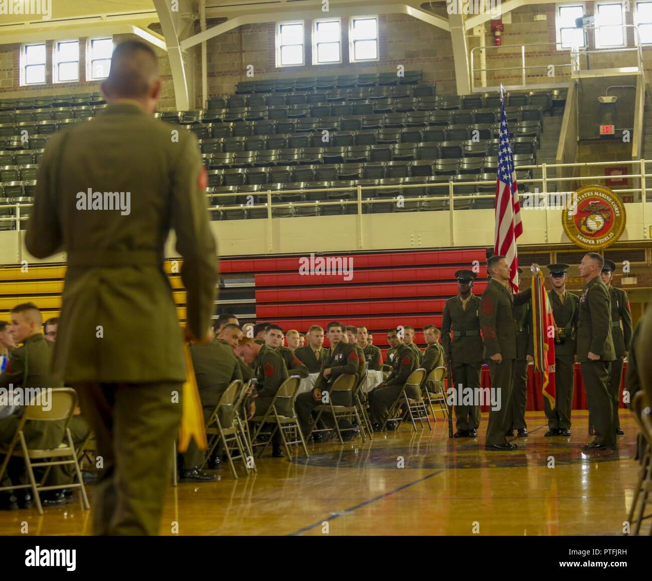 A Marine carrying an award streamer approaches the unit colors during ...